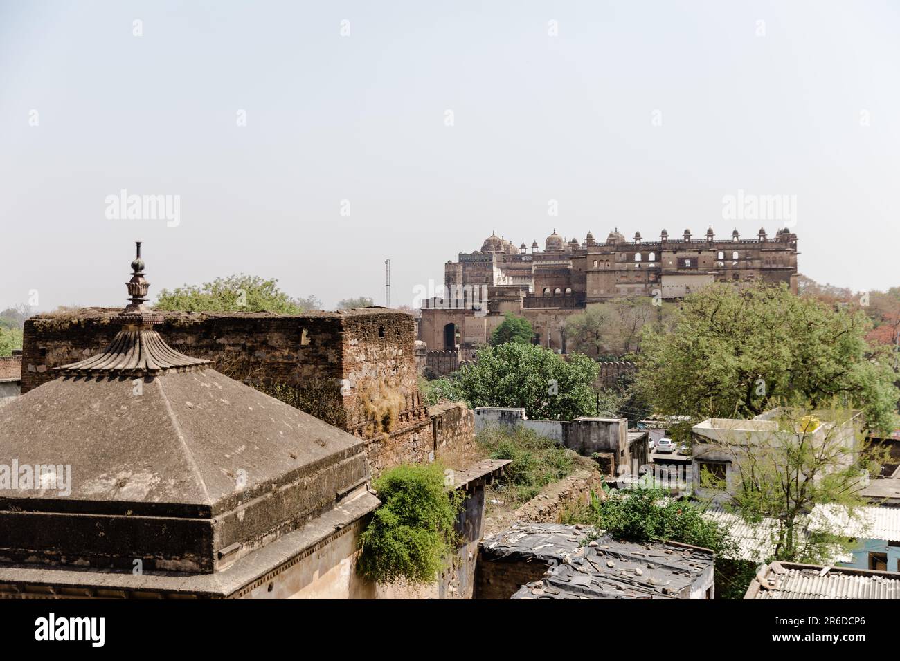 An aerial view of Orchha Fort in India in the distance, sunlit with a ...