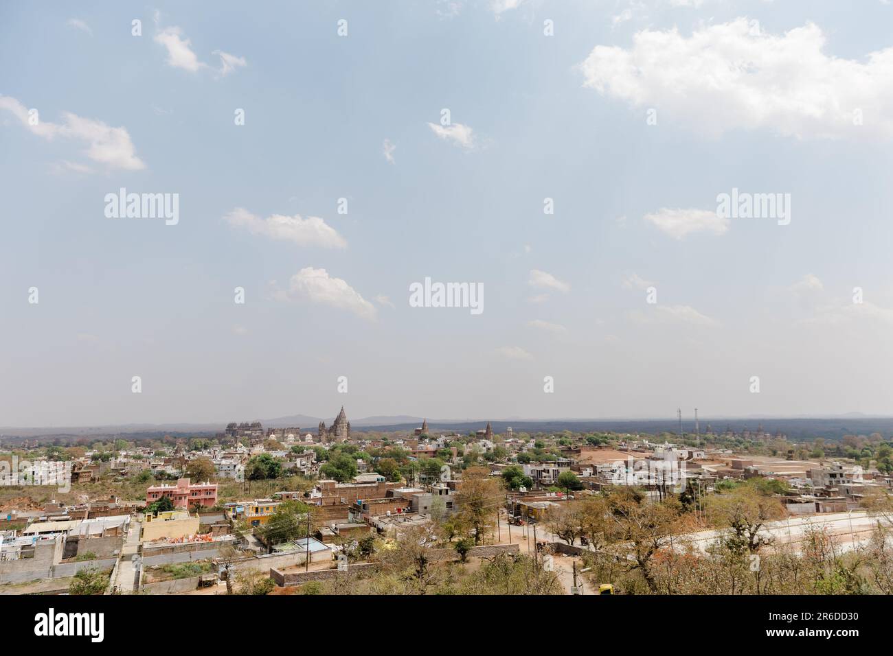 An aerial view of Orchha Fort in India in the distance, sunlit with a ...