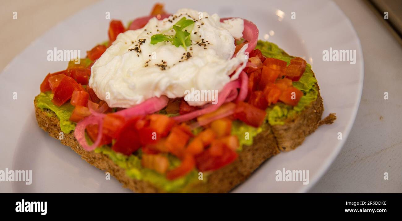 Avocado and egg toast with pickled onions and tomatoes Stock Photo - Alamy