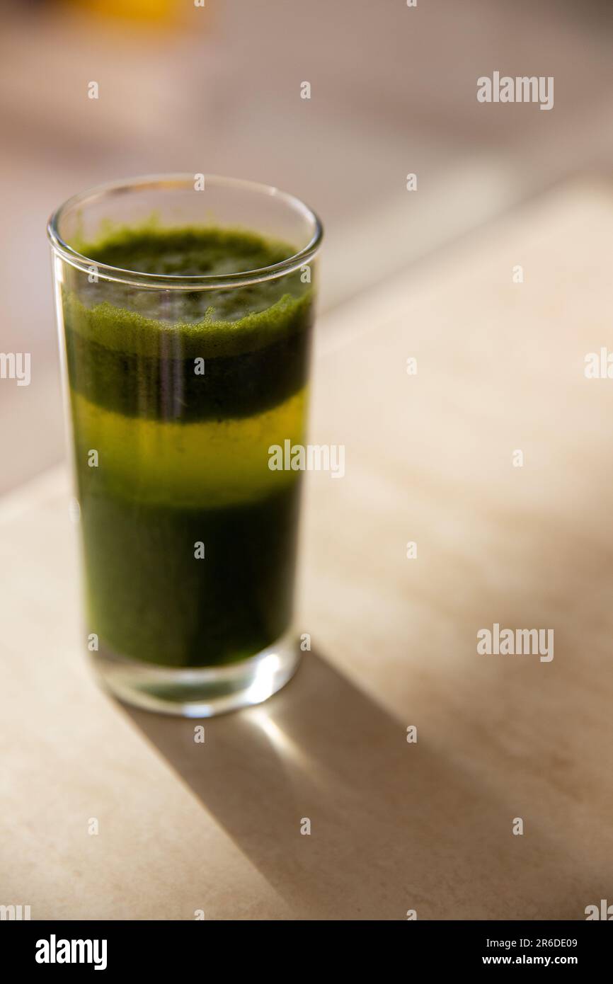 a glass of layered healthy green juice Stock Photo - Alamy