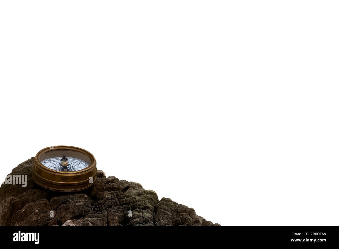 Vintage brass compass on a weathered wood post isolated on white with ...