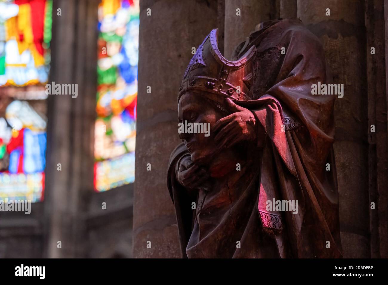 Statue of St. Denis of France holding his own head. Sculpture is bathed ...