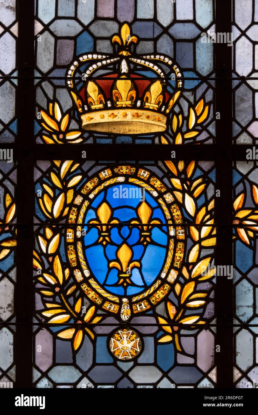 Detail of stained glass panel with a crown, gold leaves, three gold ...