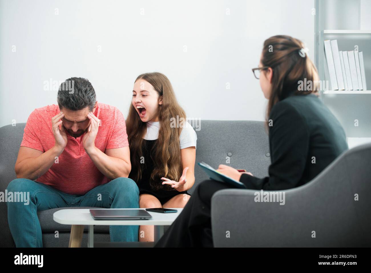 Social worker psychologist talking to father and daughter teenage ...