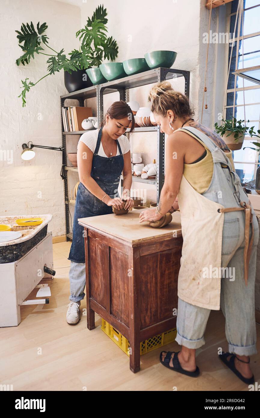 The best class for a budding potter. two young women kneading clay in a ...