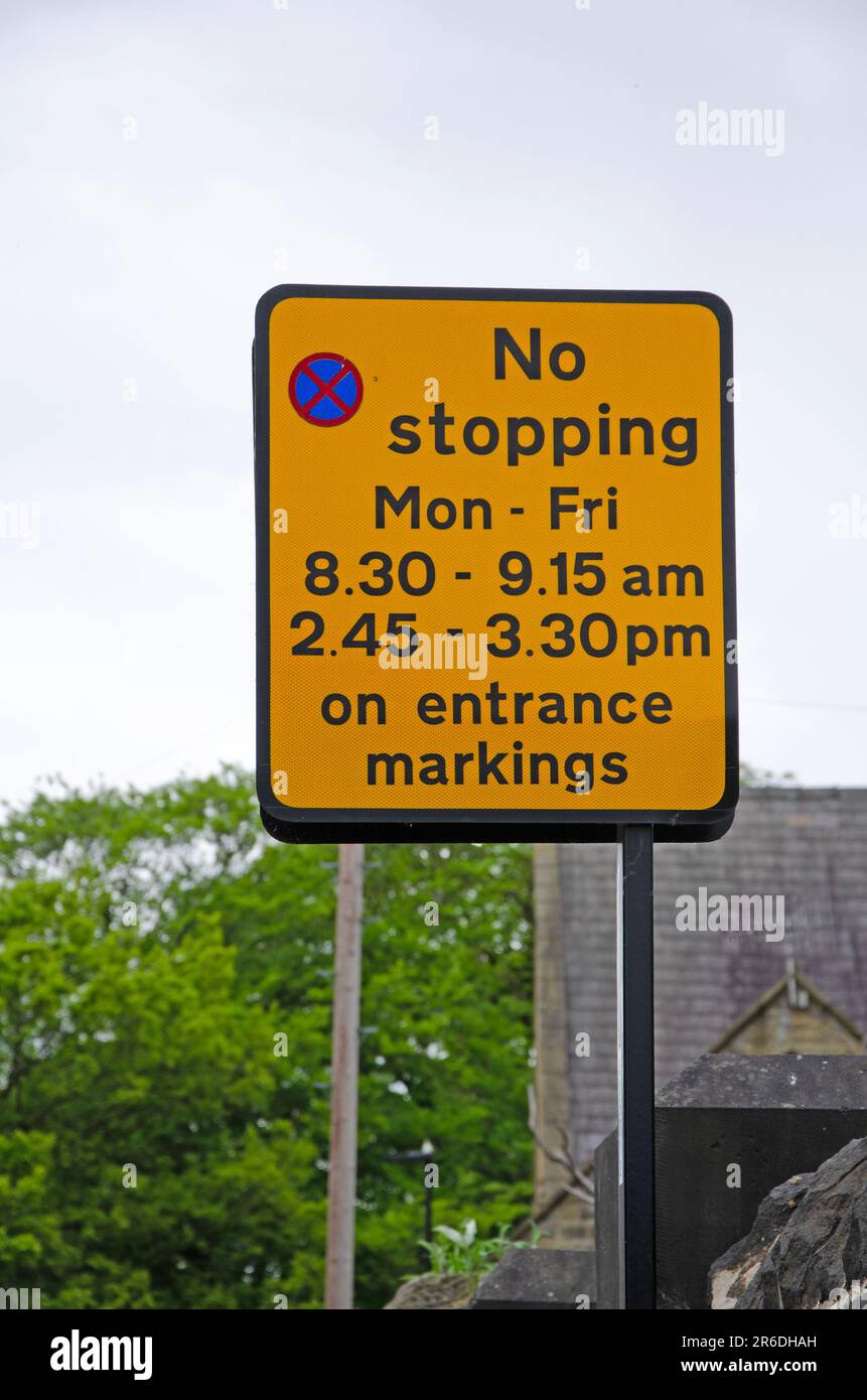No stopping on entrance markings sign with times Stock Photo - Alamy