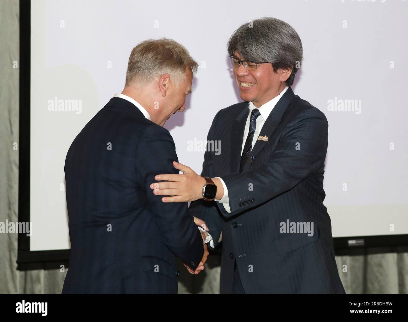 Founder and CEO of Prologium Vincent Yang, right, shakes hands with the ...