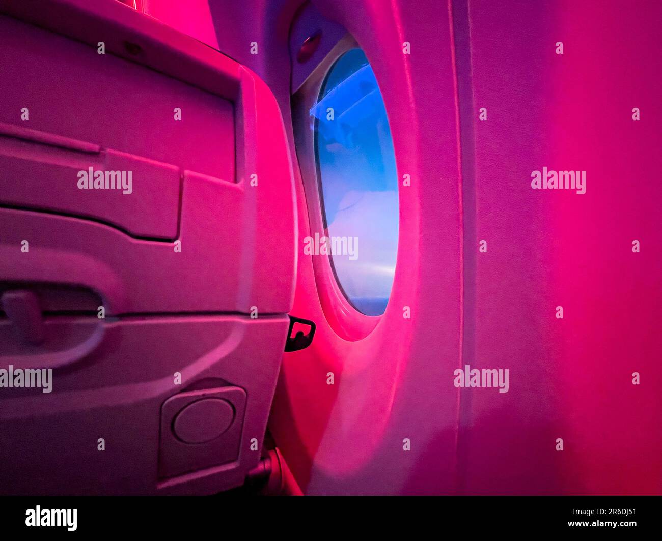 Window showing the wing of a commercial wide-body aircraft rising to ...