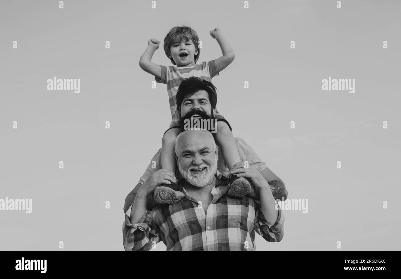 Excited. Father and son playing outdoors. Happy smiling boy on shoulder ...