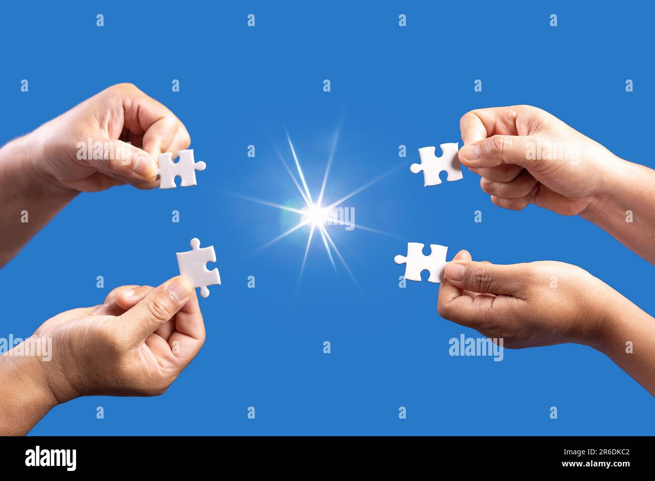 Hands holding jigsaw puzzles piece with clear blue background, success ...