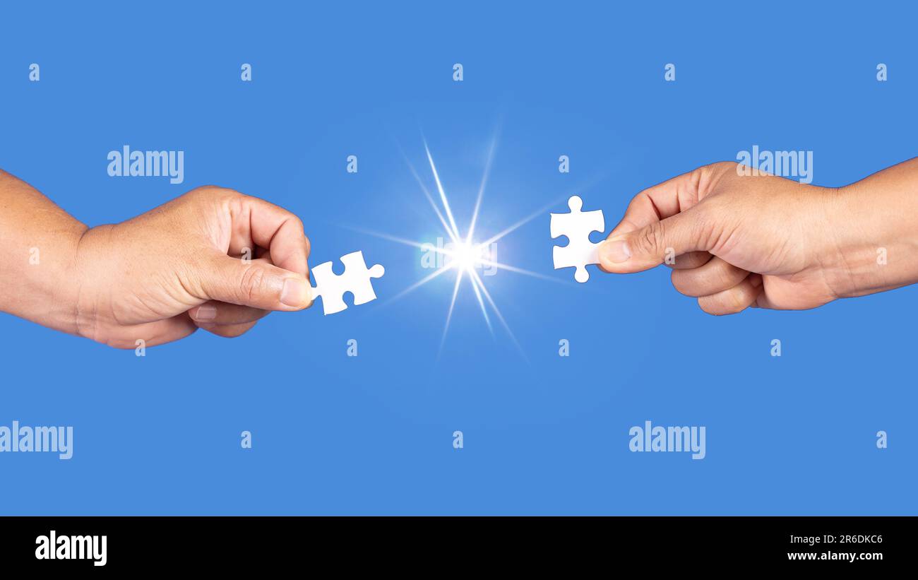 Hands holding jigsaw puzzles piece with clear blue background, success ...