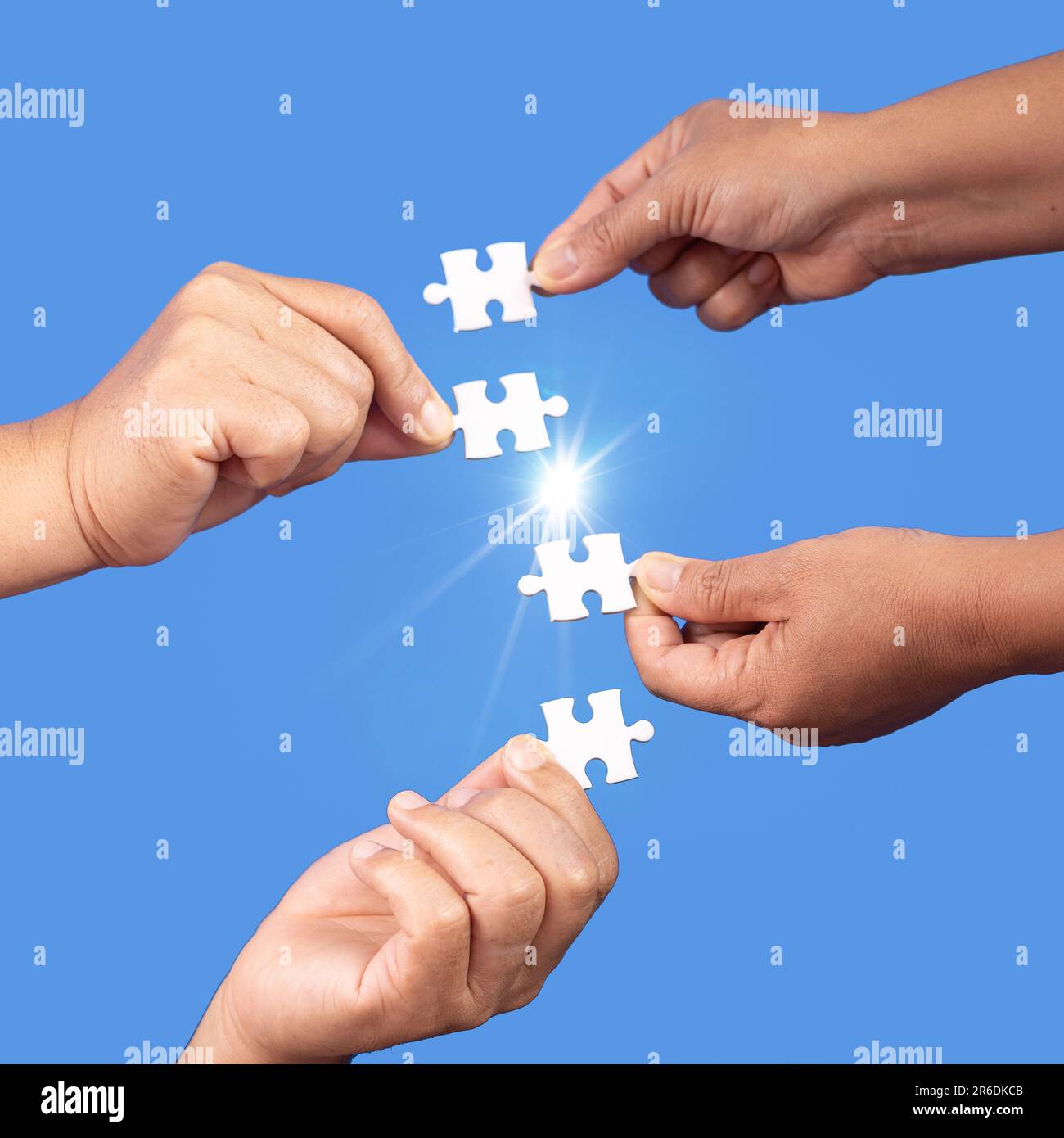 Hands holding jigsaw puzzles piece with clear blue background, success ...