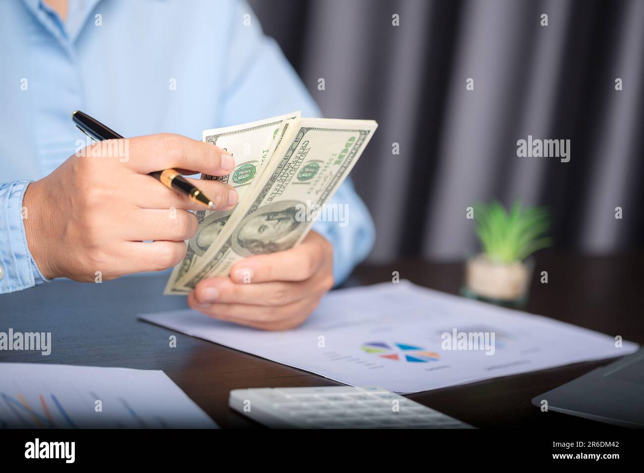 Close up young business woman using counting cash money one hundred dollar bills, checking ...