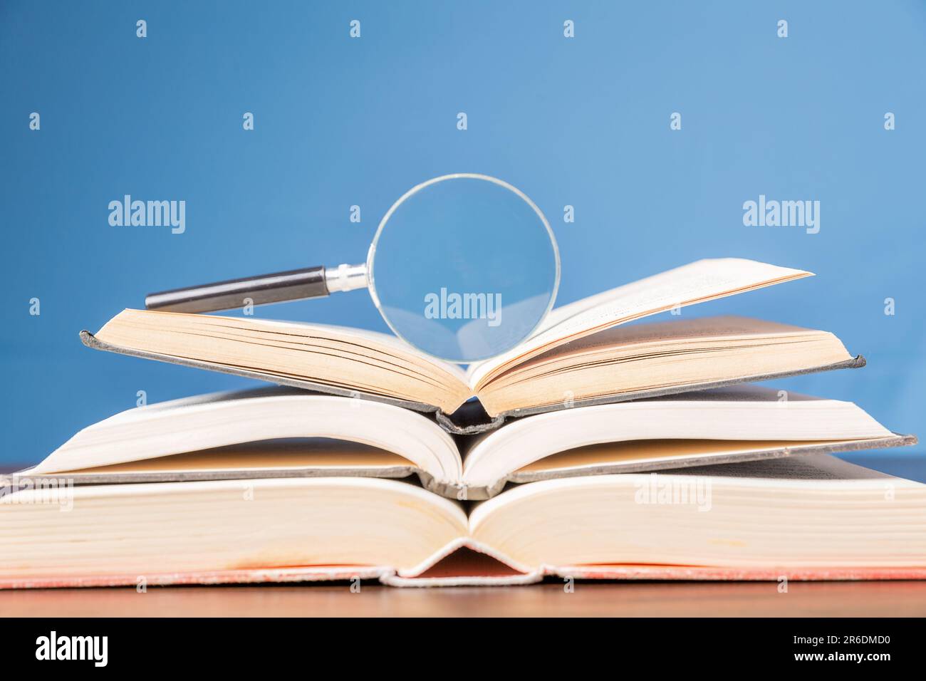 open book with magnifying glass on wooden desk in information library ...