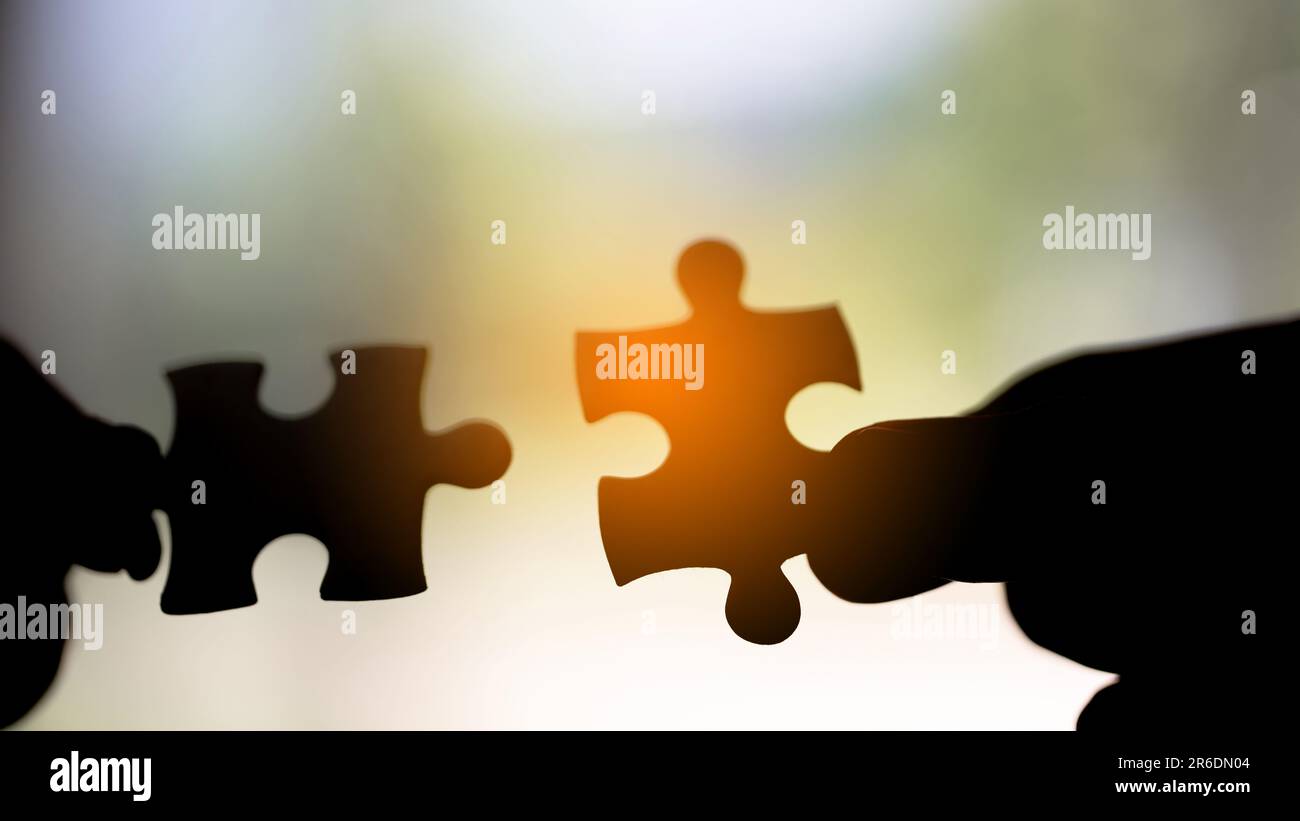 Closeup hand of woman connecting jigsaw puzzle with sunlight effect ...