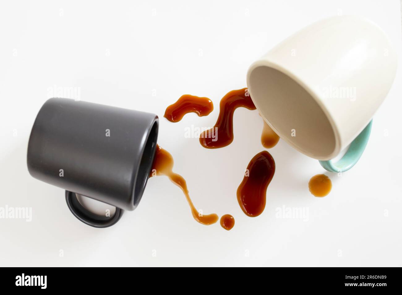 two cups of coffee with brown spill on white background, soft focus ...