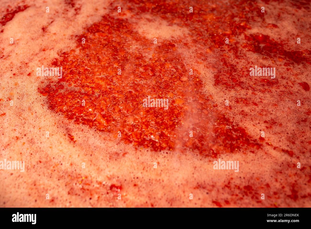 Boiling strawberry jam with steam and bubbles, soft focus side view ...