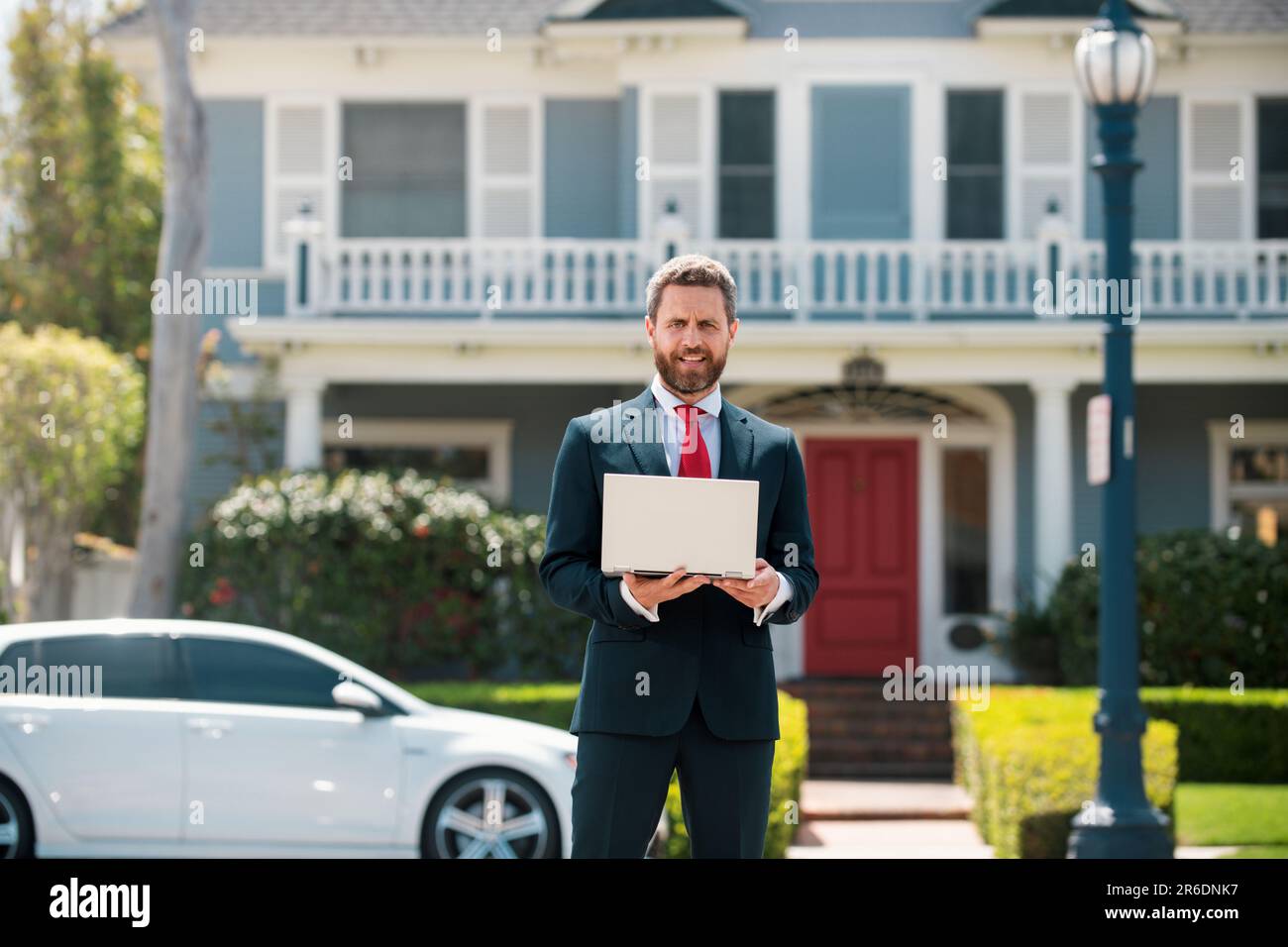 Real estate agent welcoming visitors near new house. Portrait of ...