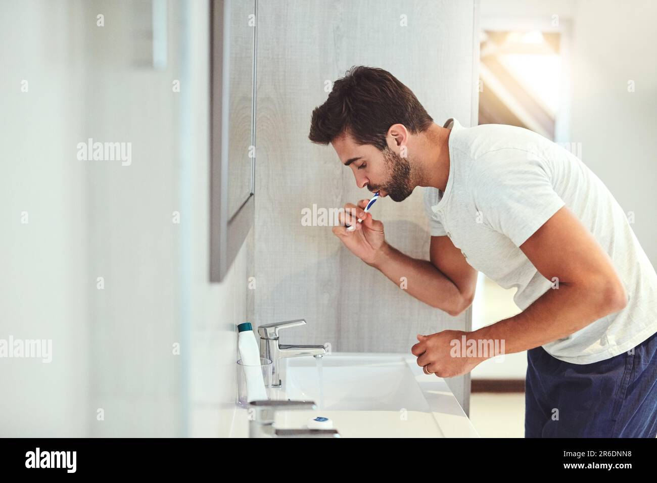 Dental, cleaning and brushing teeth with man in bathroom for habit ...