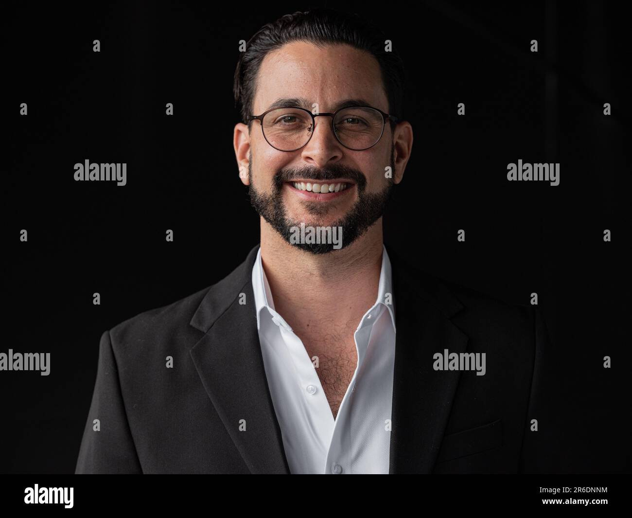 Portrait of successful businessman against black background Stock Photo ...