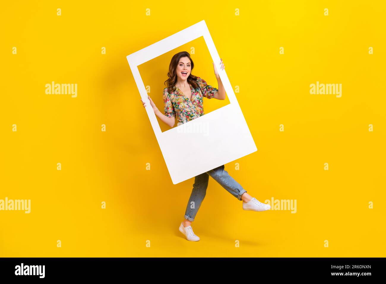 Full body length cadre of young girl dancing have fun hold paper frame ...