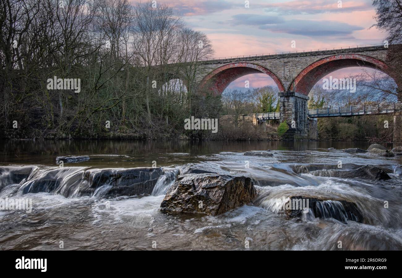 A picturesque river flowing underneath a bridge with a clock tower ...