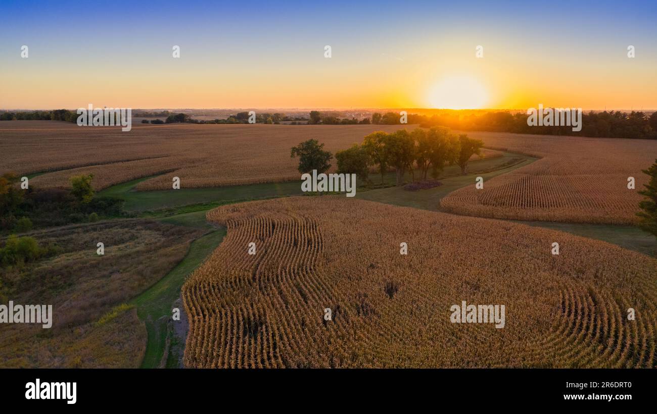 An expansive outdoor landscape featuring a bright orange sunset over ...