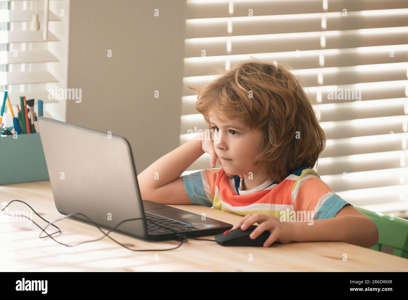 School boy sitting at the table, writing homework or preparing for the ...