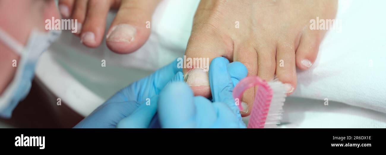 Podiatrist making professional pedicure of toe nails in beauty salon ...