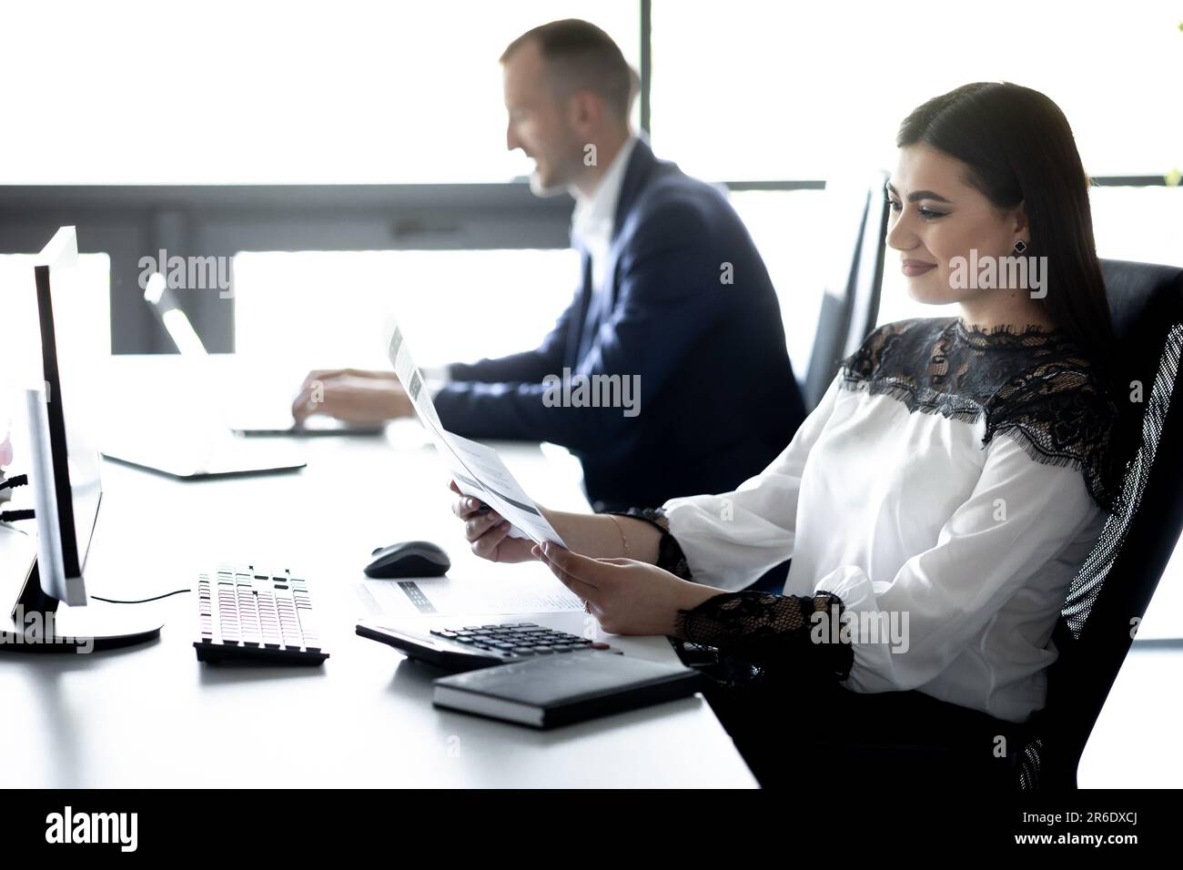 Two corporate professionals working diligently together at their office ...