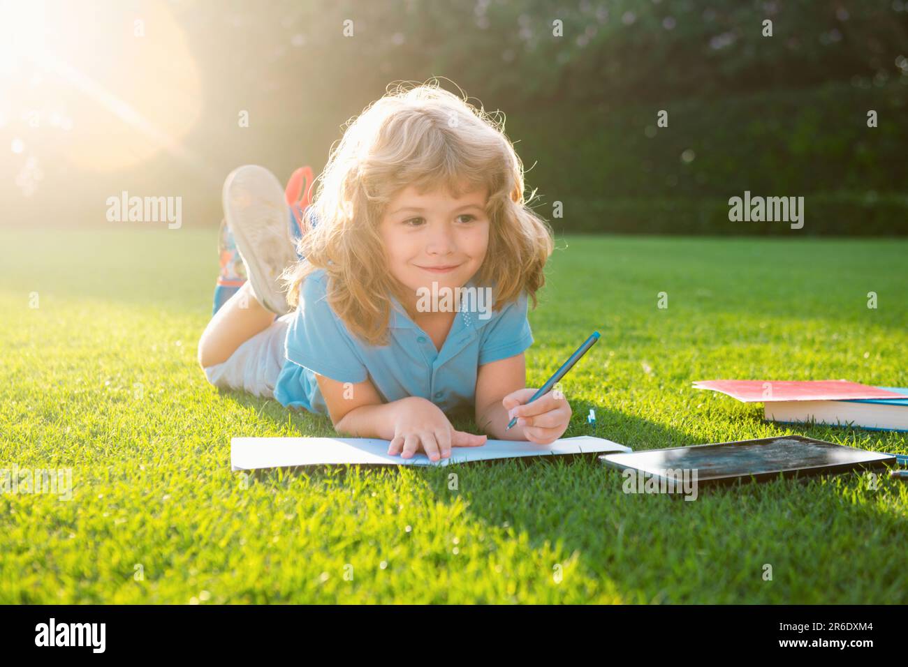 Cute childr boy writing notes in copybook outdoors. Summer camp. Kids ...