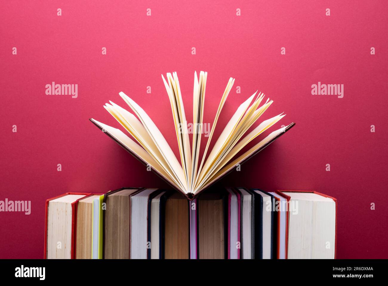 Books and notebooks in row with opened notebook on top and copy space ...