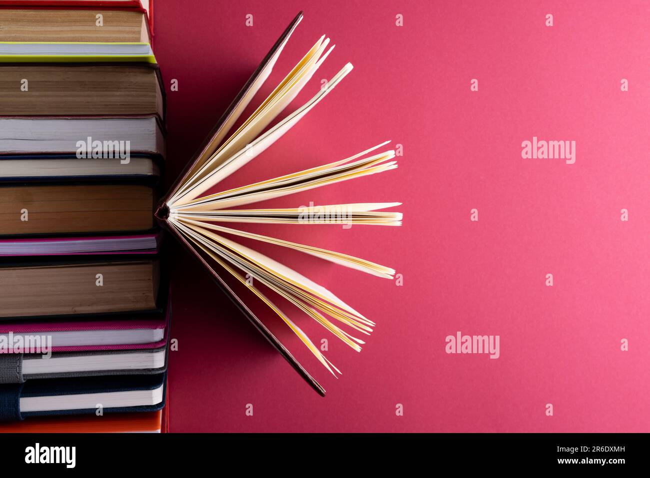 Books and notebooks in row with opened notebook on top and copy space ...