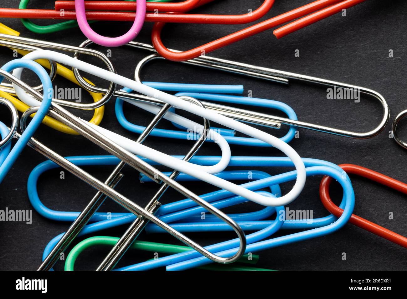 Close up of close up of multi coloured paper clips on black background ...