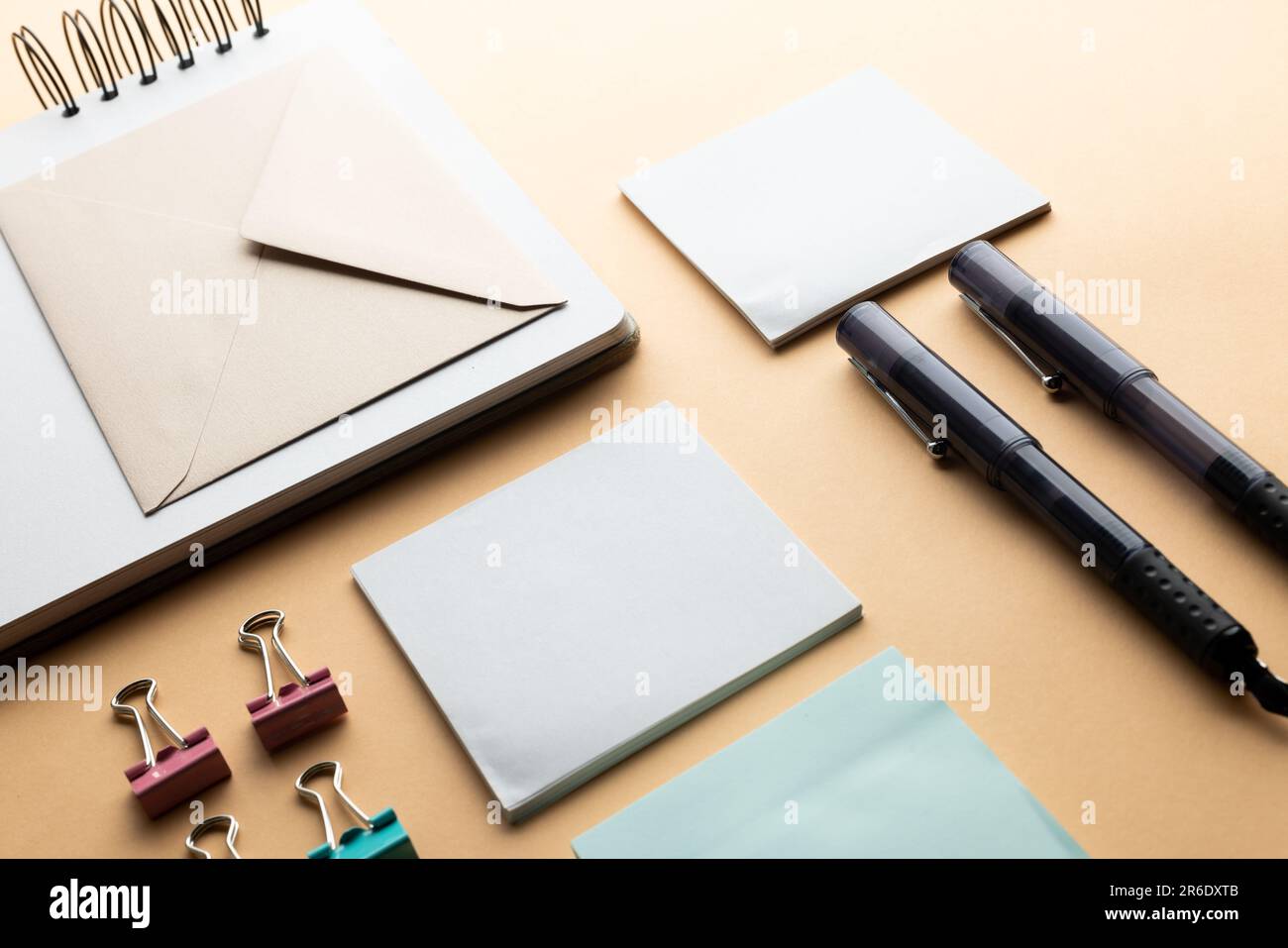 Flat lay of black pens, envelope, paper clips and memo notes with copy ...