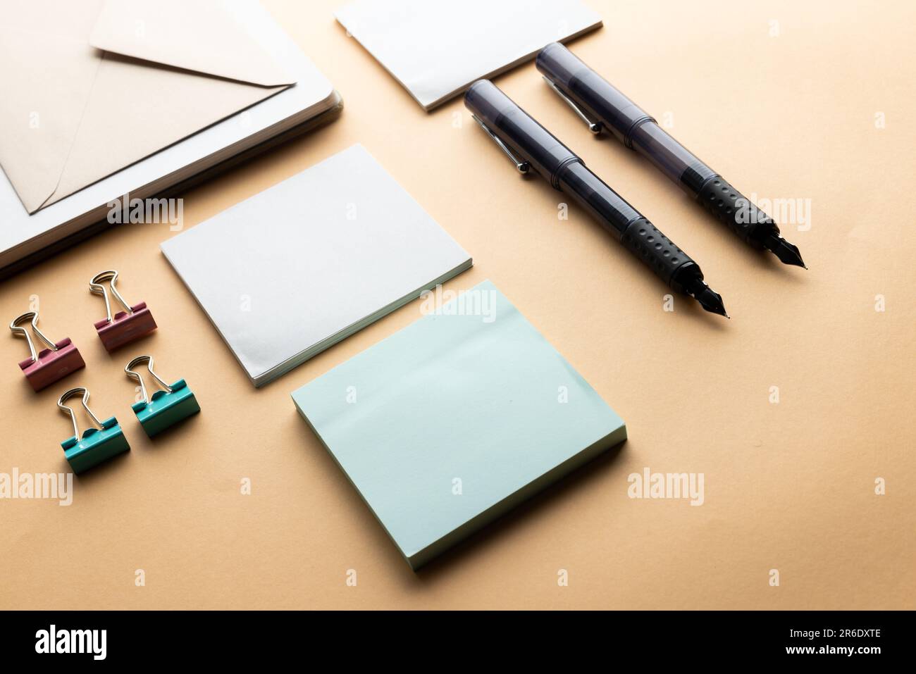 Flat lay of black pens, envelope, paper clips and memo notes with copy ...