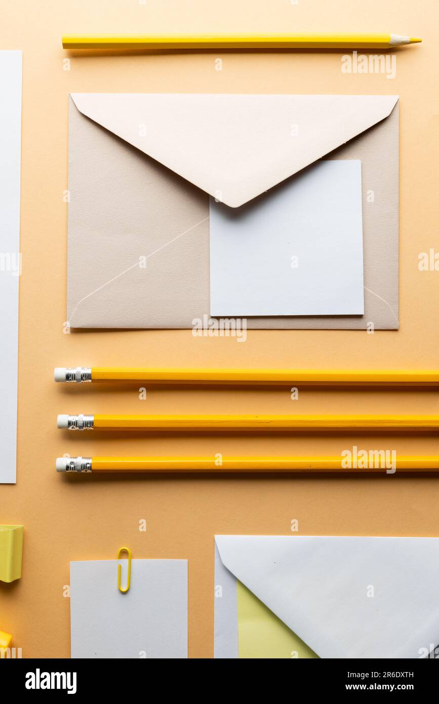 Flat lay of yellow pencils and envelope, white paper with copy space on ...