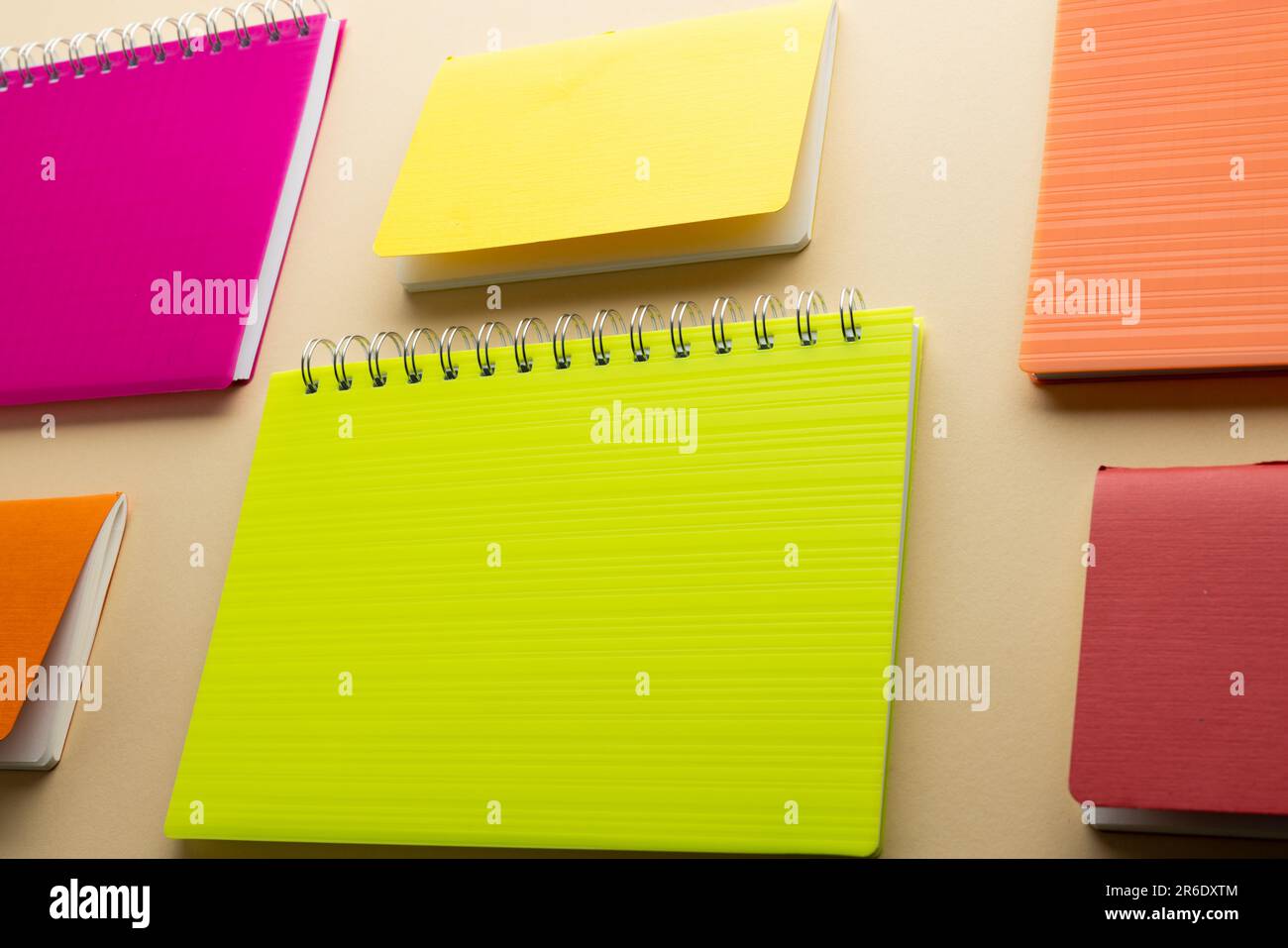 Multi coloured notebooks and copy space on orange background. Reading ...