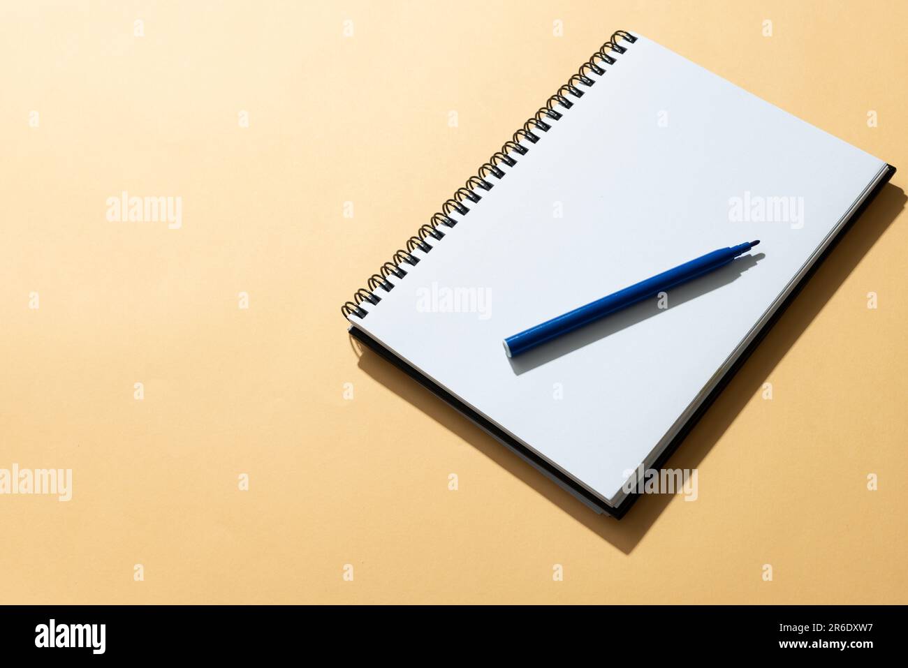 Flat lay of notebook and blue marker with copy space on yellow ...