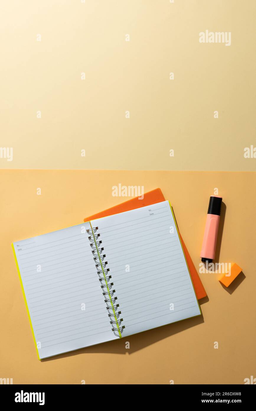 Flat lay of notebooks and highlighter with copy space on yellow ...