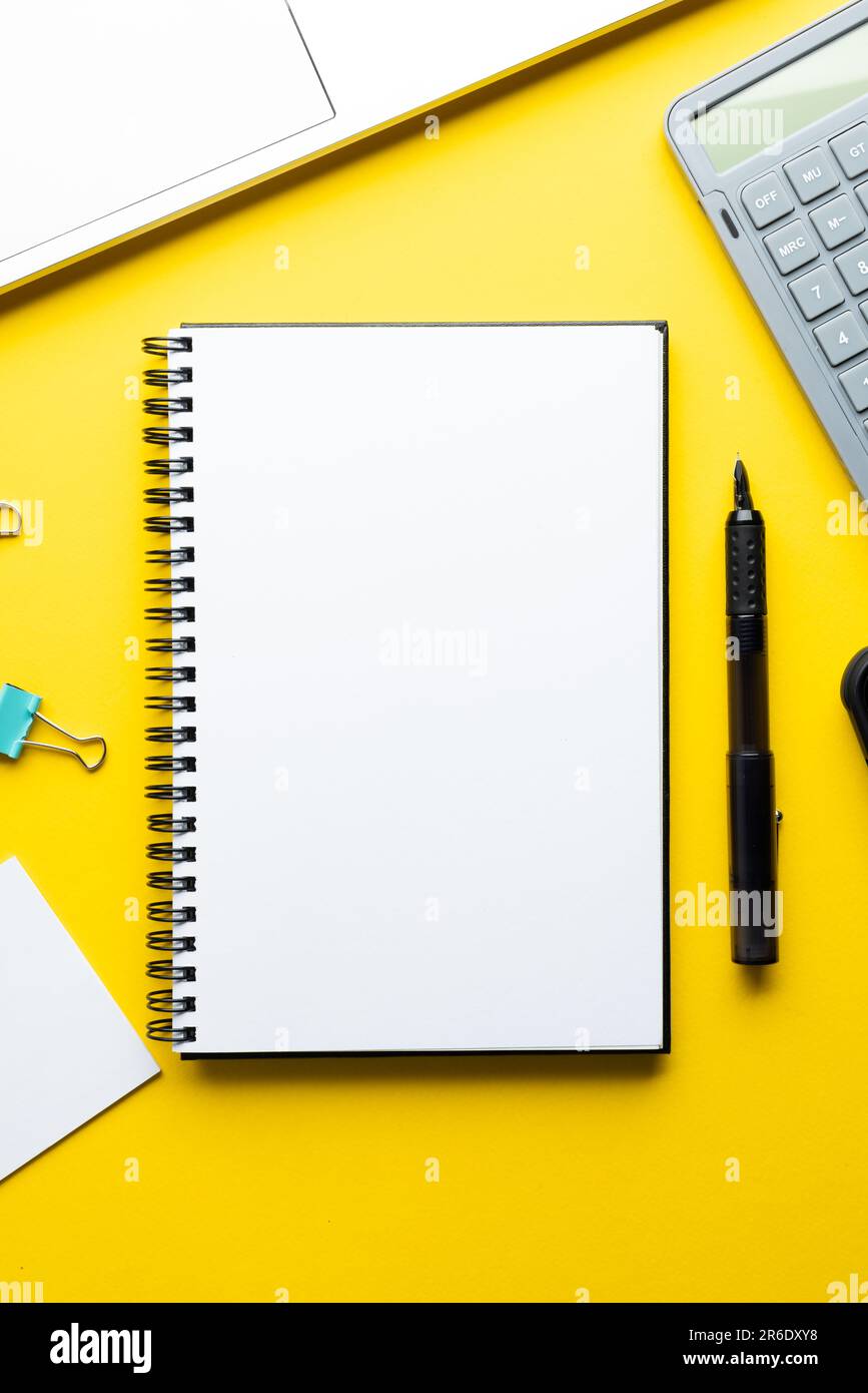 Flat lay of notebook with copy space and school materials on yellow ...