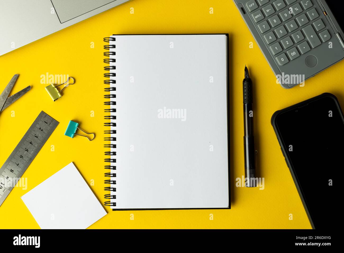 Flat lay of notebook with copy space and school materials on yellow ...