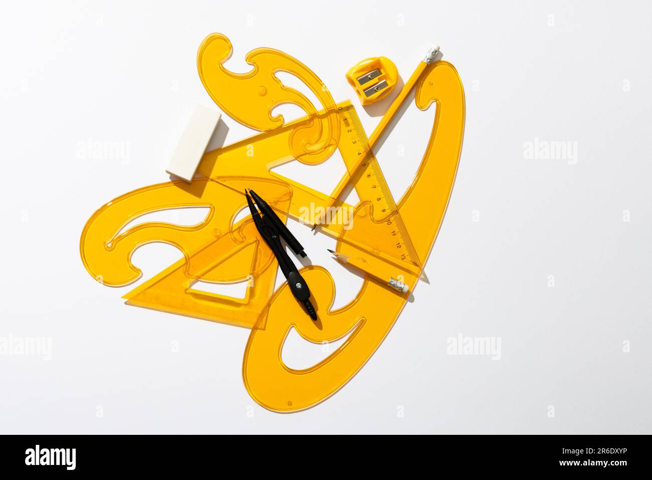 Close up of yellow rulers, compass and sharpener on white background ...