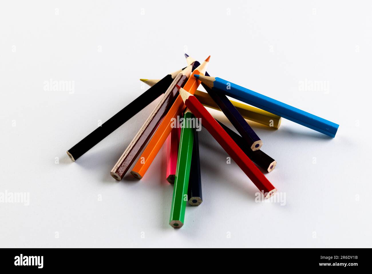 Close up of stack of coloured pencils with copy space on white ...