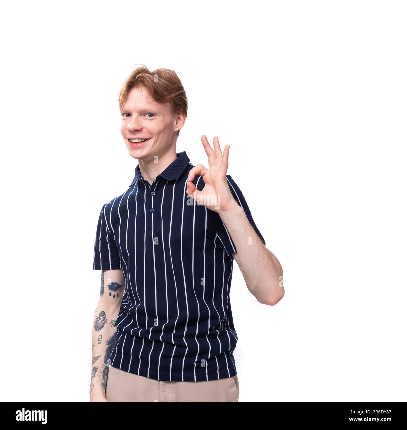 handsome well-groomed 25 year old blond male with tattoos in a striped ...