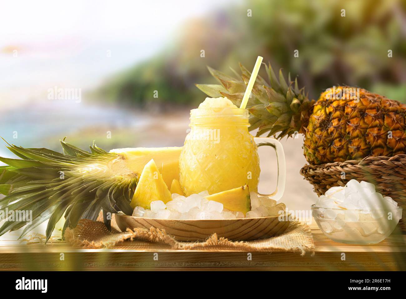 Pineapple slush with fruit around it on a wooden table outside with ...