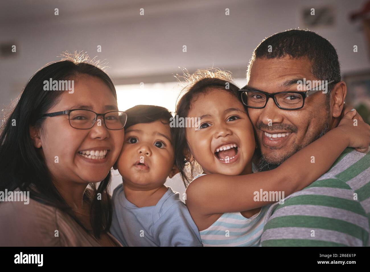 Portrait, laugh and happy family hug in a living room, excited and ...