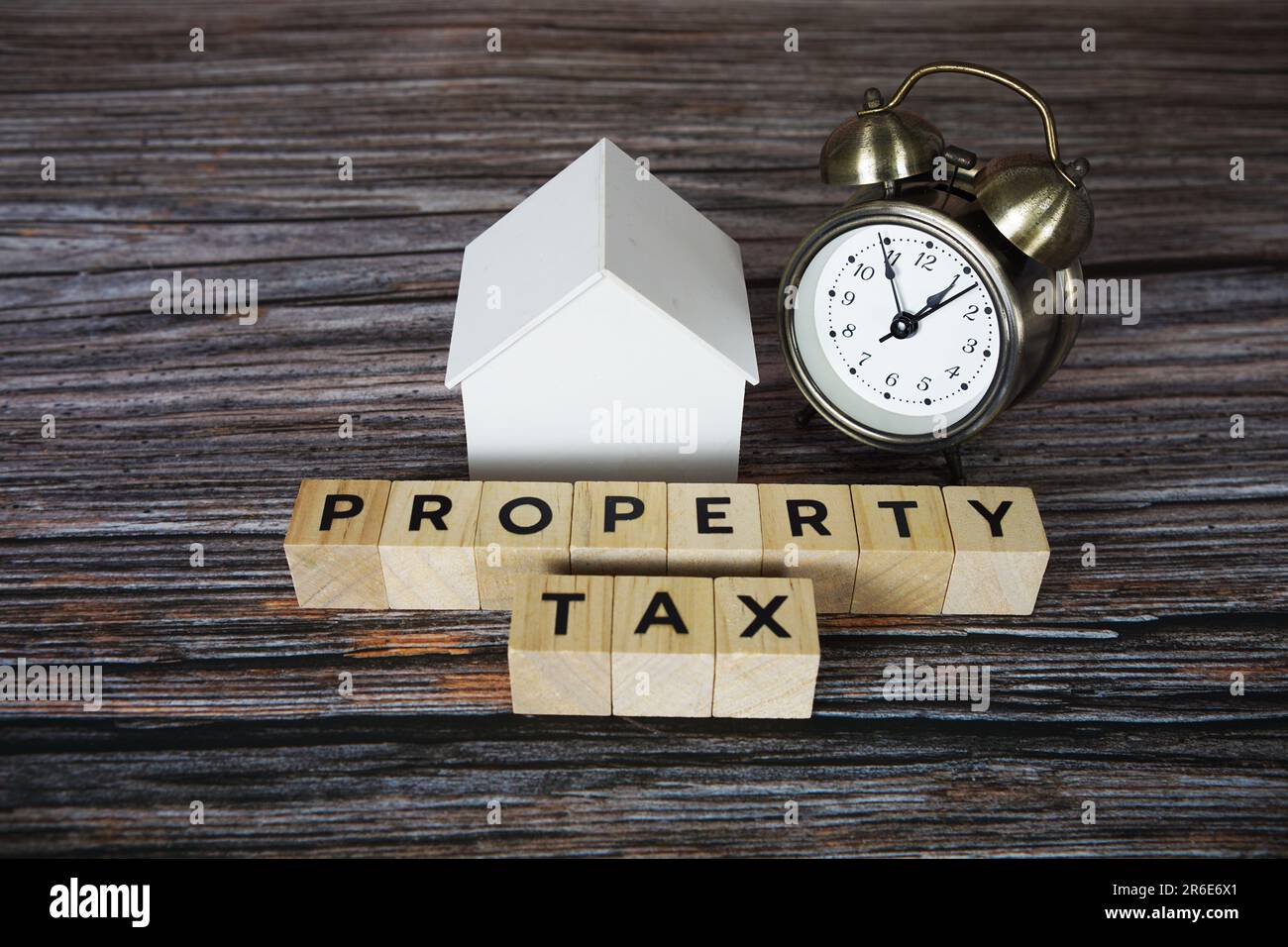 Property Tax alphabet letter with house model and alarm clock on wooden ...