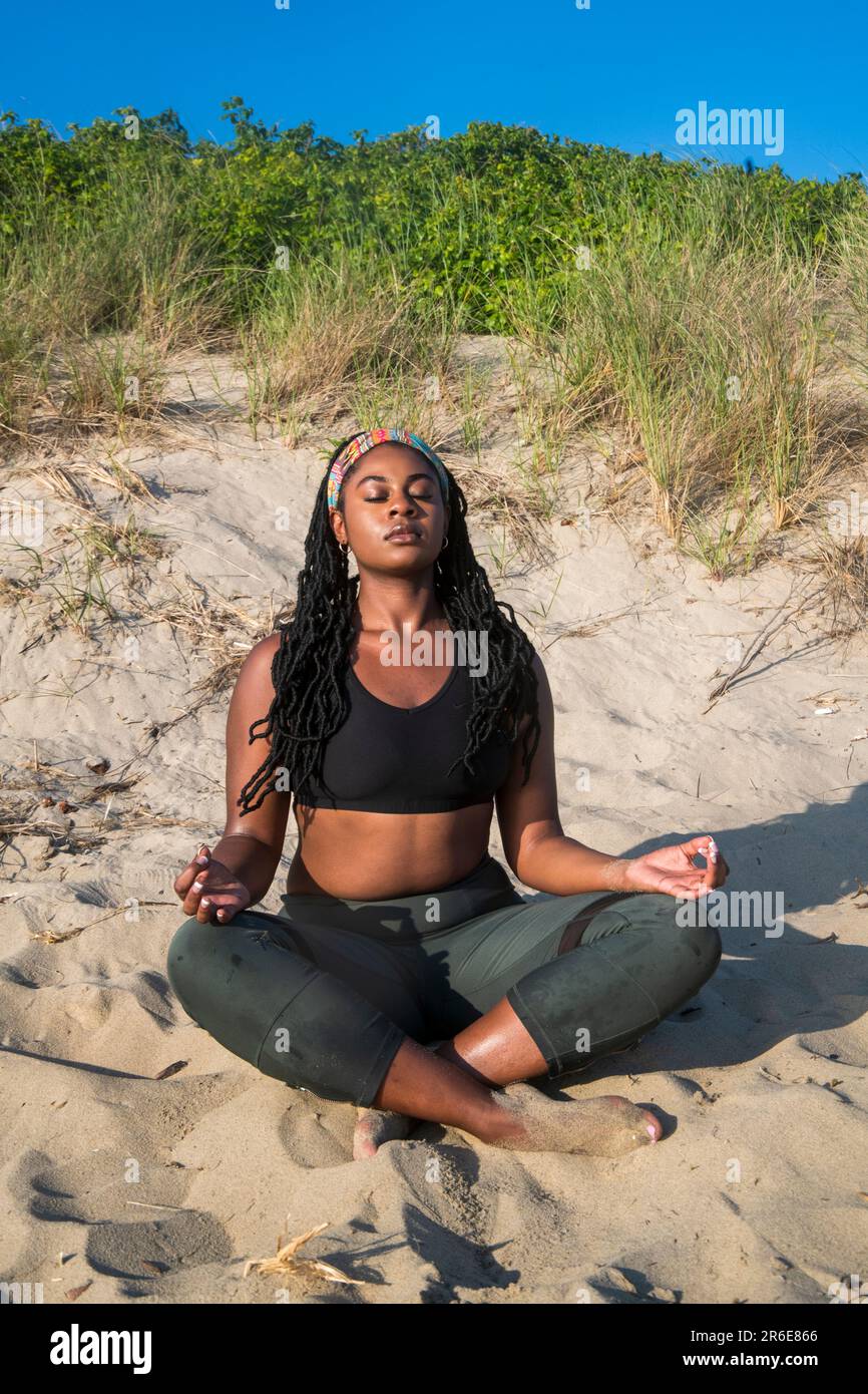 yoga at the beach with atlhletic afro american woman Stock Photo - Alamy