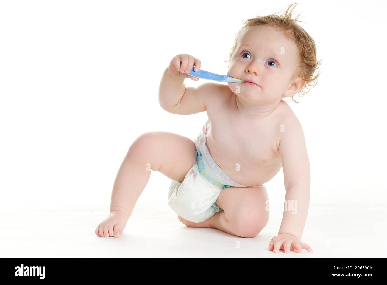 Cute baby in nappy brushes her own teeth Stock Photo - Alamy